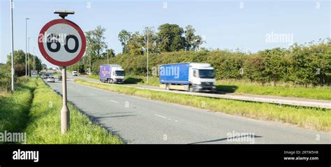Fast Moving Heavy Goods Vehicle Passes A Speed Restriction Sign Stock