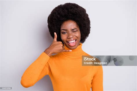 꼬리 치는 행복 예쁜 어두운 피부 여자의 사진 은 회색 색상 배경에 고립 된 손가락 제스처 윙크 눈을 호출합니다 갈색 머리에