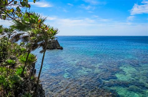 Roatan 섬 온두라스입니다 풍경 열 대 푸른 청록색 맑은 바다 물 바다 암초 백그라운드에서 푸른 하늘입니다 그린 리프 바위에
