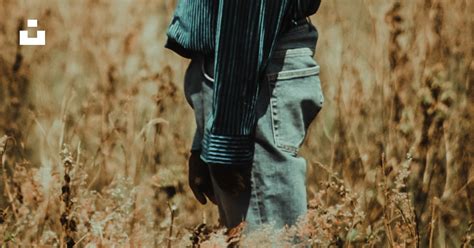 Man In Blue And White Striped Dress Shirt And Brown Pants Standing On
