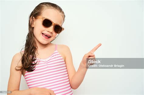 흰색 배경 착용 수영복과 빈 공간을 향해 손가락으로 가리키는 선글라스에 대 한 촬영 젖은 머리와 작은 유치원 소녀를 웃 고 가리키기에 대한 스톡 사진 및 기타 이미지