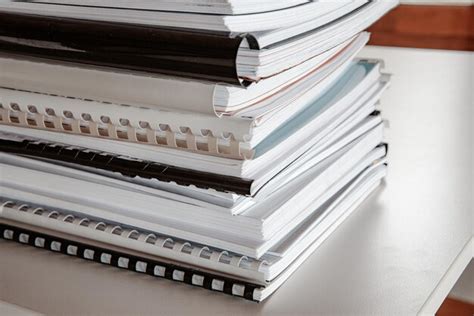 Premium Photo Stack Of Binded Workbooks On A Table