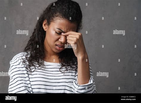 Upset Stressed African Woman Suffering From A Headache Over Gray Wall