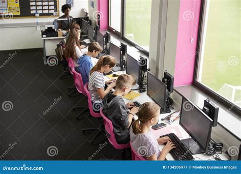 Female Teacher Supervising Line Of High School Students Working At
