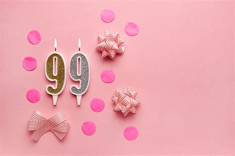 축제 장식이 있는 파스텔 핑크 배경에 99번 생일 축하 촛불 생일 기념일 중요한 날짜 휴일을 축하하는 개념입니다 복사 공간 기치