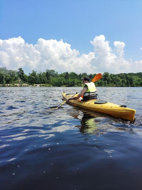 Premium Photo A Young White Guy In A Cap Swims In A Kayak Against The