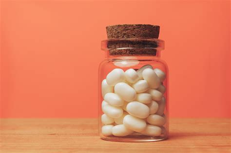빨간 나무 테이블에 알 약에 대 한 유리 병 아름 다운 Corall 오렌지 배경입니다 0명에 대한 스톡 사진 및 기타 이미지