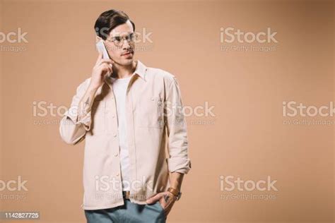 잘생긴 남자 안경에 스마트 폰에 서 있는 동안에 고립 된 베이지색 남자들만에 대한 스톡 사진 및 기타 이미지 남자들만 무선