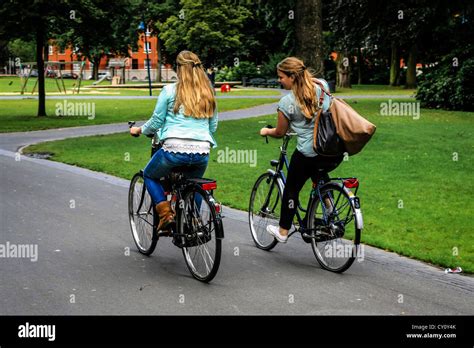 Two Dutch Girls Riding Their Bicycles Through The Park In Breda Holland