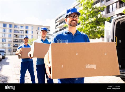 Hardworking Delivery Men Transporting Cardboard Boxes In Van