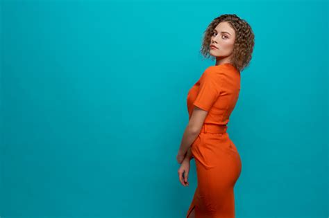 นางแบบที่มีสไตล์ในชุดสีส้มยืนโพสท่า ภาพสต็อก ดาวน์โหลดรูปภาพตอนนี้ การถ่ายภาพ ภาพ การยืน