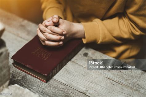 그리스도인의 삶의 위기를 하나님께 드리는 기도 손을 잡은 여자는 나무 식탁에서 더 나은 삶을 살기를 바라는 하나님의 축복을