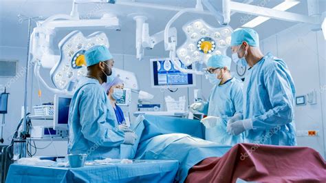 Equipo Diverso de Cirujanos Profesionales que Realizan Cirugía Invasora a un Paciente en la Sala ...