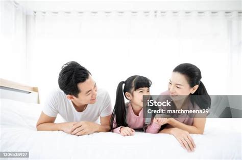 행복한 아시아 가족 사람들은 함께 침실에서 레저 아버지와 어머니 와 딸 휴식 에 침대 와 재미 있는 3 명에 대한 스톡 사진 및