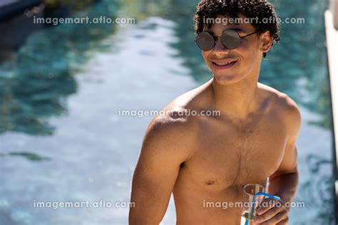 Happy Shirtless Biracial Fit Man In Sunglasses Drinking Cocktail