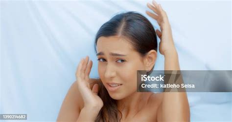 하얀 배경 뒤에서 손이 그녀에게 손을 뻗는 동안 불안해 보이는 젊은 여성의 스튜디오 샷 20 24세에 대한 스톡 사진 및 기타