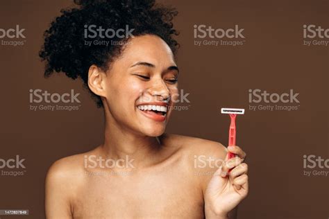 웃고 면도기를 바라보는 평온한 젊은 여성의 수평 보기 벌거벗은 어깨를 가진 웃는 여자의 초상화 베이지색 배경에 고립된 아름다운 소녀 25 29세에 대한 스톡 사진 및 기타
