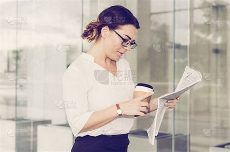 严肃忙碌的女商人戴着眼镜读着新报纸