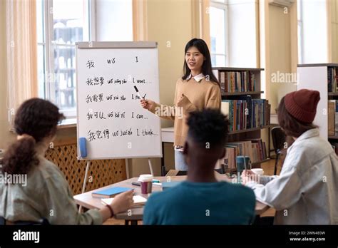 Portrait Of Young Asian Woman Teaching Chinese Language Class To Group