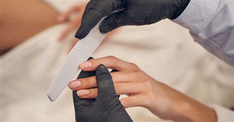 전문 파일을 사용하는 동안 고객의 손톱 형태를 신중하게 형성하는 숙련 된 매니큐어 사 사진 Unsplash의 못 이미지