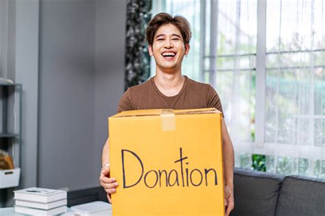 기부 개념 기부를위한 기부 상자를 들고있는 행복한 자원 봉사 아시아 남자 자선 센터에서 일하는 웃는 남성 결정에 대한 스톡 사진 및 기타 이미지 Istock