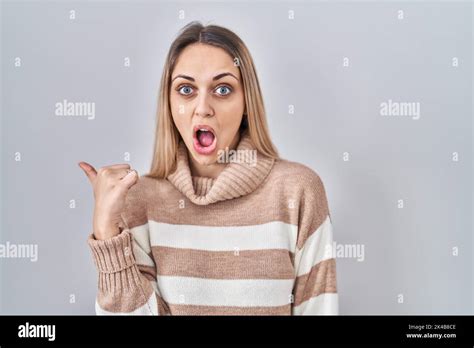 Young Blonde Woman Wearing Turtleneck Sweater Over Isolated Background