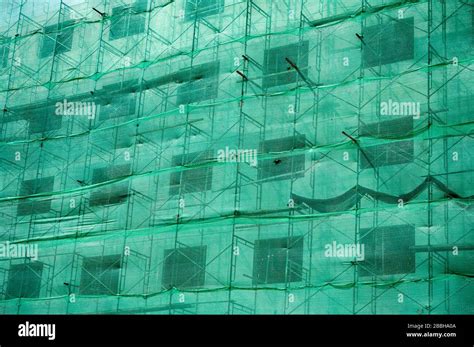 Building Structure With Green Netting Shade And Scaffolding Covered