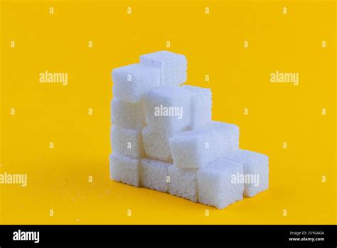 Sugar Cubes Are Arranged In A Pyramid Shape Against A Vivid Yellow Background The Structure