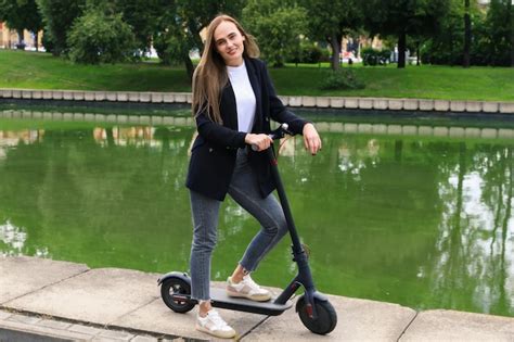 Premium Photo A Young Woman Poses With An Electric Scooter While