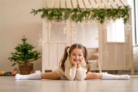 Premium Photo A Cute Little Gymnast Girl Is Sitting On A Splits
