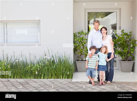 Family smiling outside front door Stock Photo - Alamy
