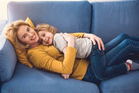 La Madre Y El Hijo Felices Están Abrazando En El Sofá Imagen de archivo Imagen de ocio resto