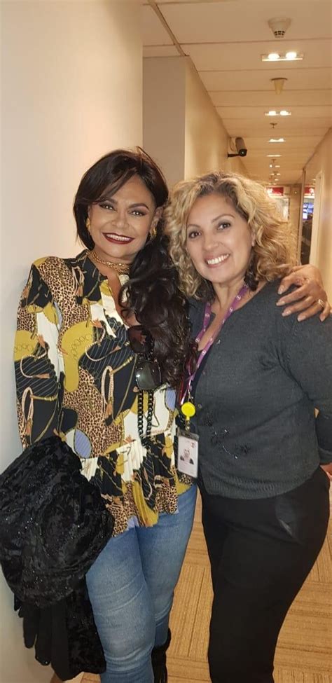 Two Women Standing Next To Each Other In A Hallway