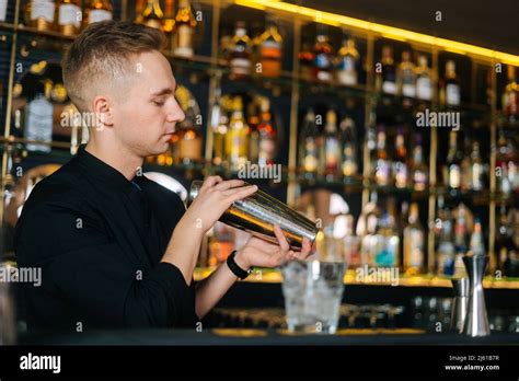 Side View Of Bartender Mixing Ingredients Of Alcoholic Cocktail By