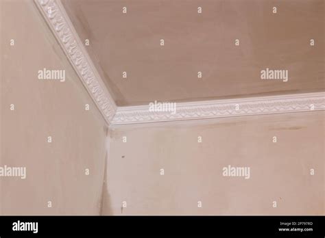 Installation Of Ceiling Moldings Worker Puts Glue On Plastic Molding