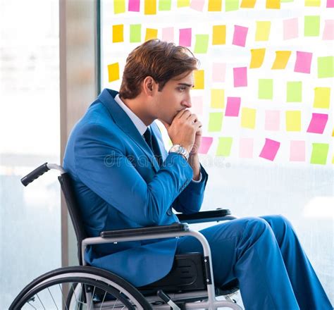 Young Handsome Man In Wheelchair With Many Conflicting Prioritie Stock