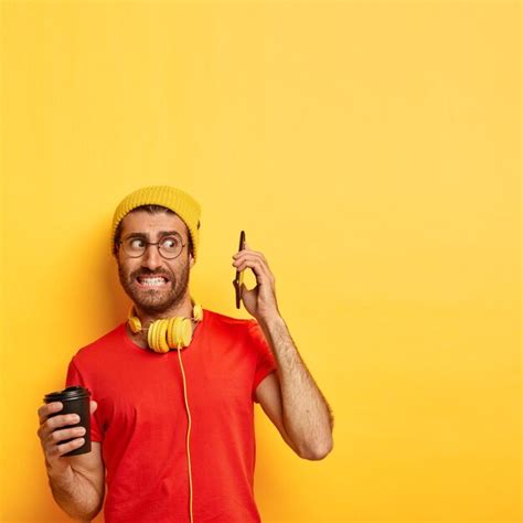 Free Photo Vertical Shot Of Puzzled Nervous Man Avoids Talking On