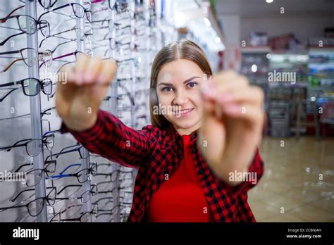 A Visually Impaired Girl Chooses Glasses She Is Wearing A Shirt And A Beautiful Smile Stock
