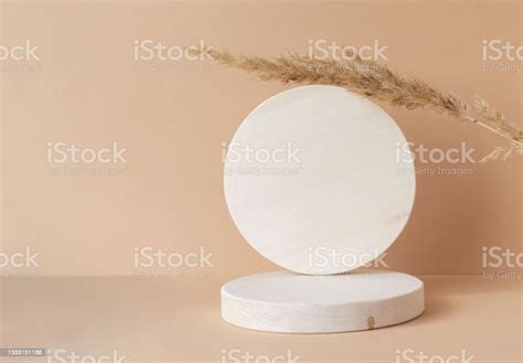 서로 위에 서 있는 두 개의 둥근 나무 인물과 베이지색 의 고립 된 배경에 클로즈업 마른 잔디의 잔가지 상품 및 화장품 의