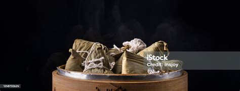 쌀 만두 Zongzi 드래곤 보트 축제 검은 배경 위에 나무 테이블에 증기선에 중국 전통 요리 음식의 무리 0명에 대한 스톡