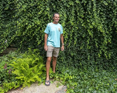 52 Year Old Caucasian Male Posing In Front Of A Dense Wall Of Green Ivy
