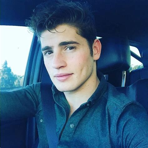 A Young Man Sitting In The Back Seat Of A Car Looking At The Camera