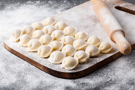 생 쌀된 러시아어 Pelmeni 절단 보드에 만든 Pelmeni 흰색 테이블에 대 한 재료 Pelmeni 라비 올 리 또는