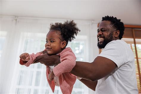 행복한 사랑을 즐기십시오 흑인 가족 아프리카 계 미국인 아버지 딸을 안고 작은 아프리카 소녀 아이 미소 짓고 즐거운 시간을 보내십시오 행복한 흑인 아프리카계 미국인 아버지의