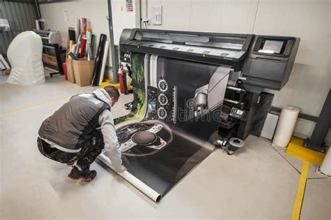 technician operator works on large premium industrial printer plotter machine stock image