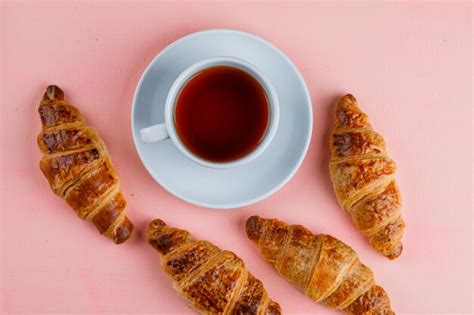 Croissants Avec Tasse De Thé Plat Posé Sur Une Table Rose Photo Gratuite