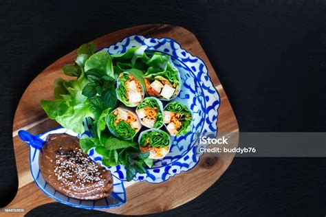 건강한 음식 개념 수제 비건 두부 여름 롤 또는 콥트 공간이 있는 검은색 배경에 땅콩 디핑 소스를 곁들인 스프링롤 스프링롤에