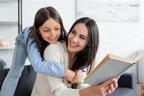 Cheerful Girl Embracing Nanny Reading Book Stock Image Image Of Adult