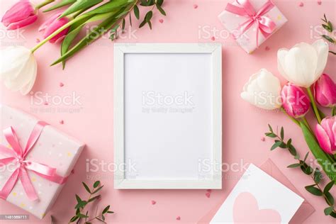 어머니의 날 개념입니다 튤립 봉투 편지의 활 다발과 빈 공간이 있는 고립된 파스텔 분홍색 배경에 뿌려진 사진 프레임 선물 상자의