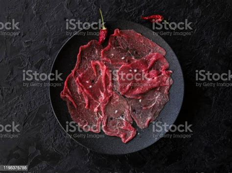 검은 슬레이트 배경에 레몬 올리브 오일 파르메산 치즈를 곁들인 대리석 쇠고기 카르파치오 맨 위 뷰 복사 공간 0명에 대한 스톡